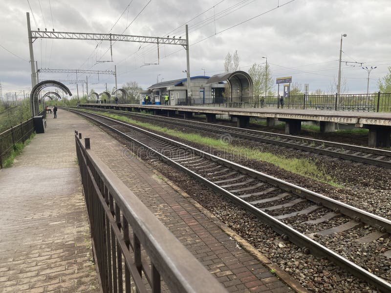 Railway Track Extends into Distance Under Overcast Sky Parallel Pathway ...