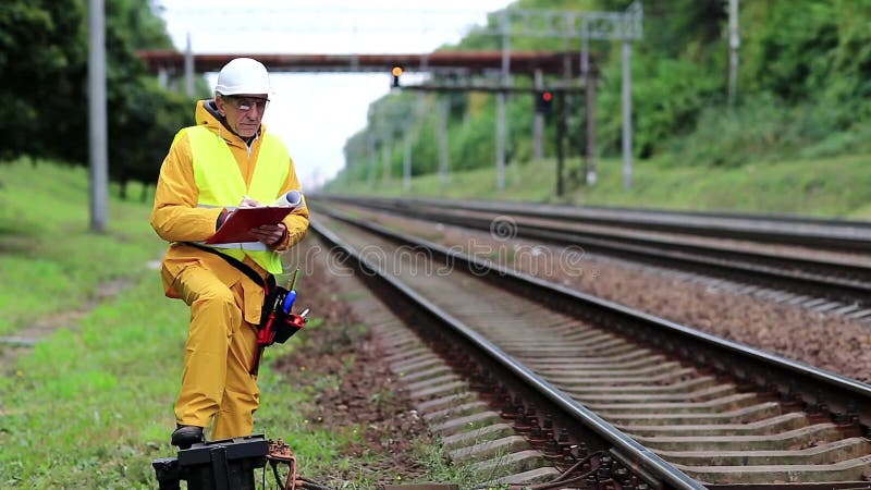 Railway Worker in Yellow Uniform and White Hard Hat with Documents in ...