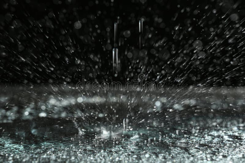 Rain Drop Falling Down into Puddle on Dark Background Stock Photo ...
