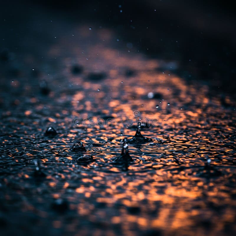 Rain Droplets Create Ripples on a Water Surface Illuminated by Warm ...