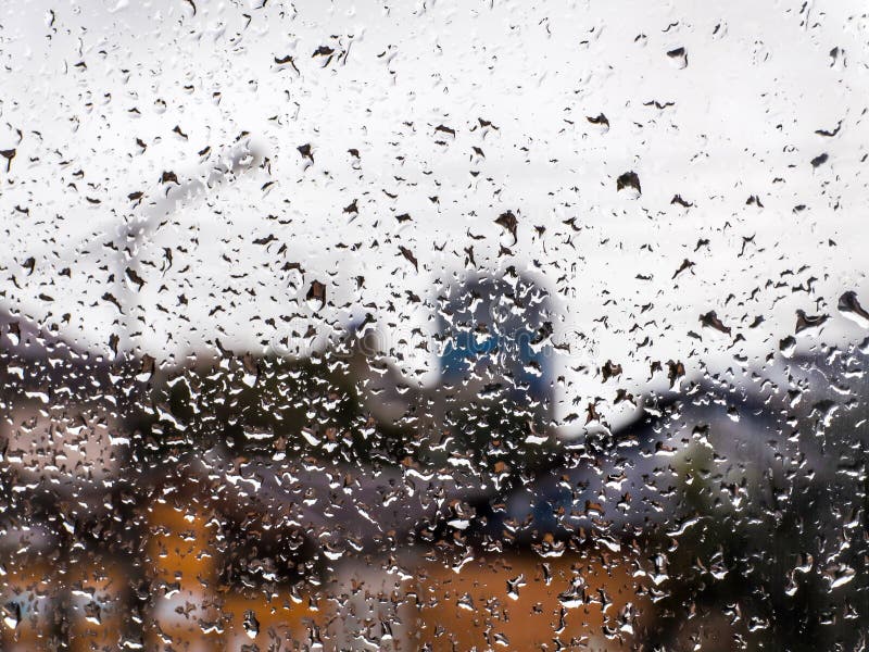 Rain Drops on Glass Window. the Cityscape Outside the Window in a Blur ...