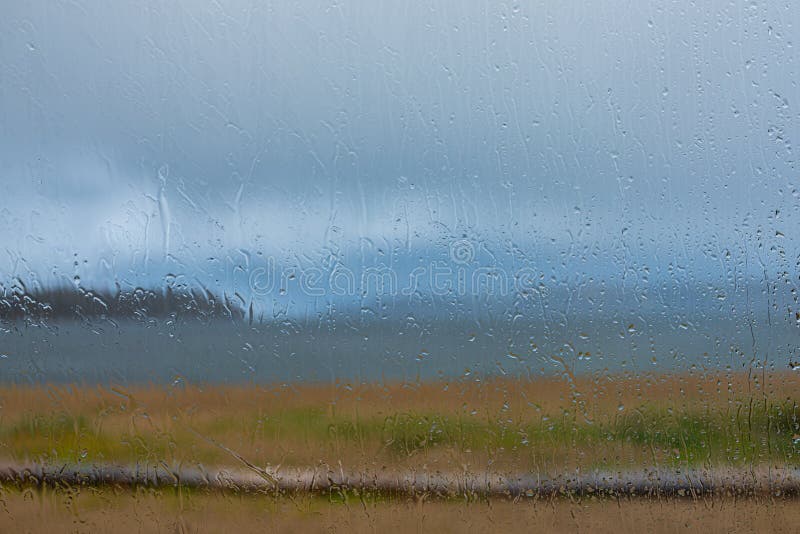 Rain Drops on a Large Panoramic Window Looking Out To Sea on a Stormy ...