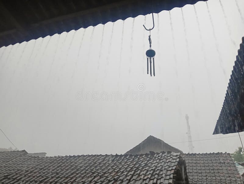 Rain Falling Heavily from a Roof, with a Wind Chime Hanging and ...