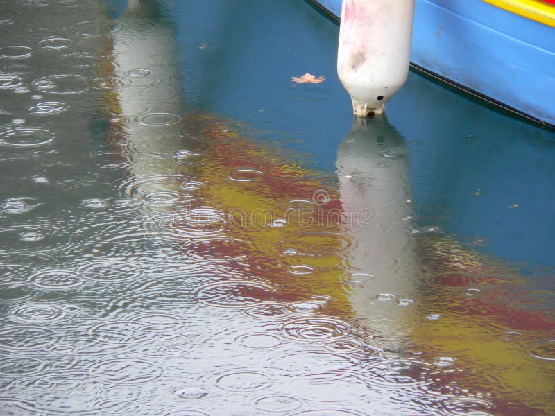Rain Falling on Water Surface with Colorful Boat Reflection Stock Photo ...