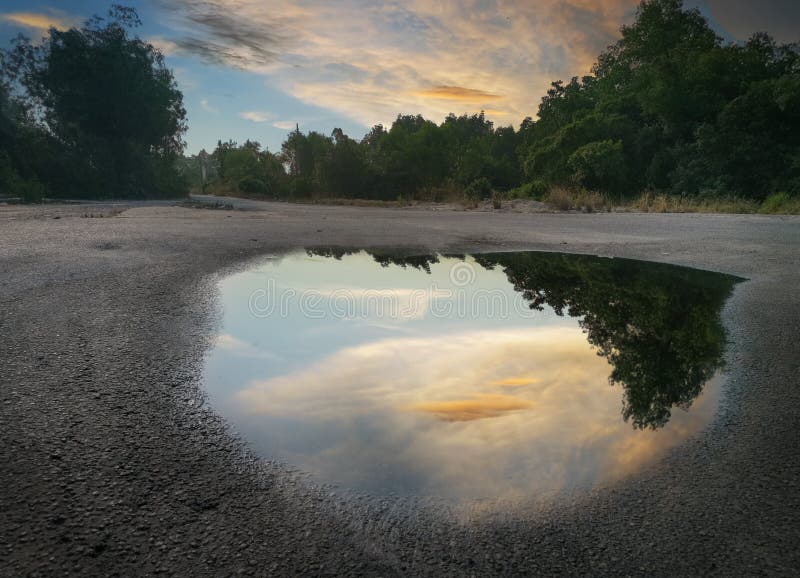 After Rain Puddle by the Road with Sky Reflection on the Surface Stock ...