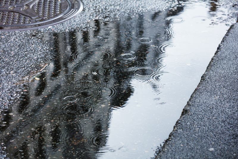 Rain Puddles on Pavement in the City Stock Photo - Image of hatch, rain ...