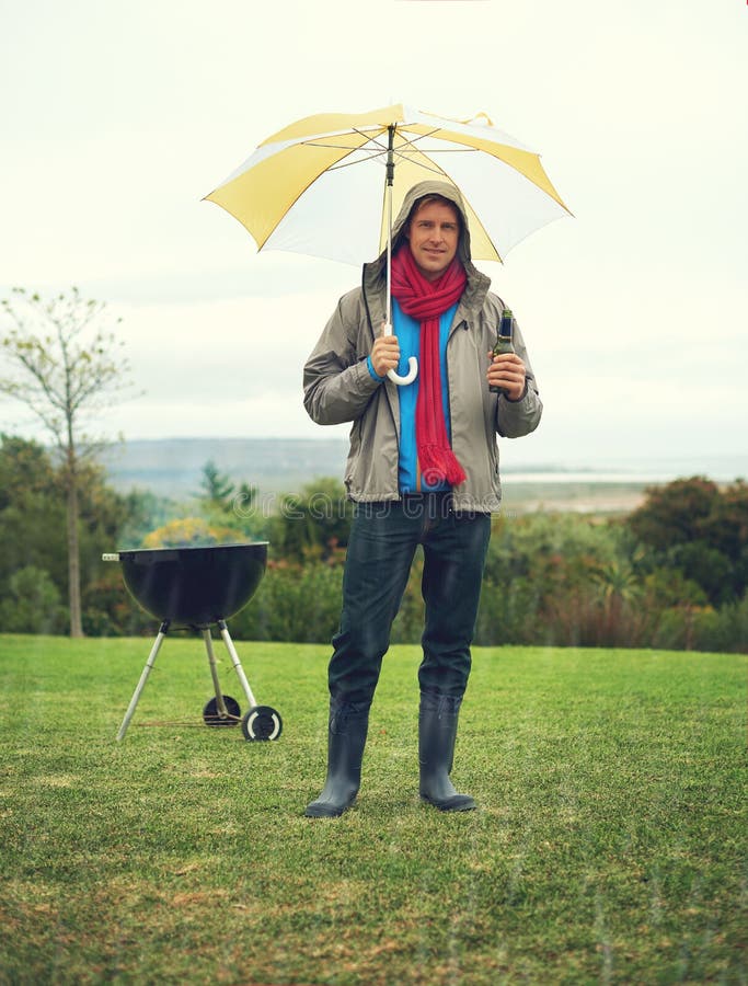 Rain is only Temporary. a Cheerful Man Barbecuing in the Rain while ...