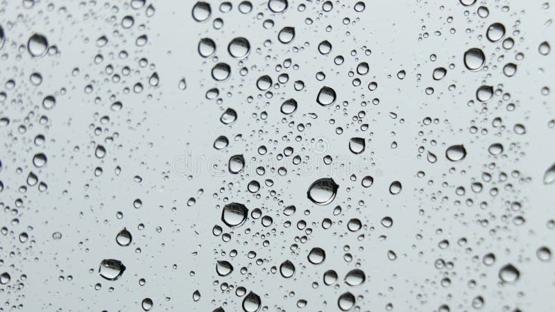 Rain Water Drops Falling on the Window Pane and Sliding Down on a Rainy ...
