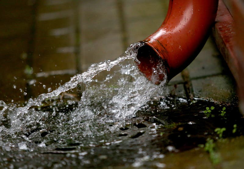 Rain Water is Pouring from the Green Draining Gutter on the Pavement ...