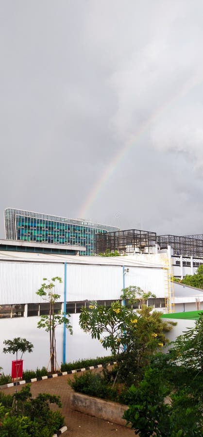 Rainbow Above the Building with Pretty Clouds Visible from a Distance ...