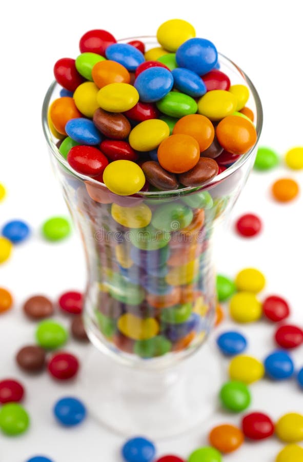 Rainbow Colored Candy Coated Chocolate Buttons in a Glass Isolated on a ...