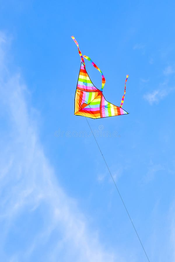 Rainbow Colored Kite Flying High in the Blue Sky with Some White Clouds ...