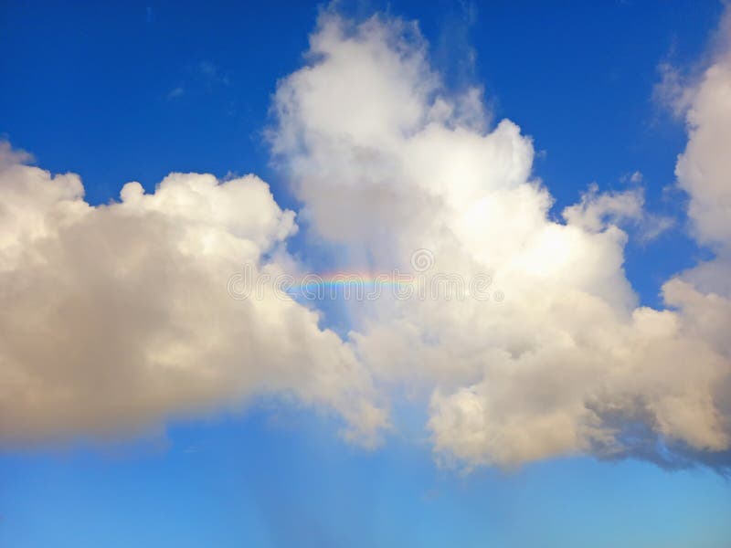 Rainbow Detail between White Clouds and Tropical Blue Sky. Spectacular ...
