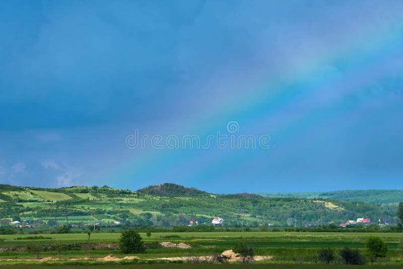 Rainbow and Distant Storm Over Hills Stock Image - Image of vegetation ...
