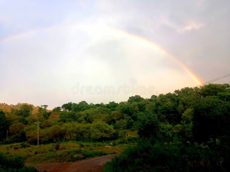 Rainbow forming in village stock photo. Image of sunlight - 186088350