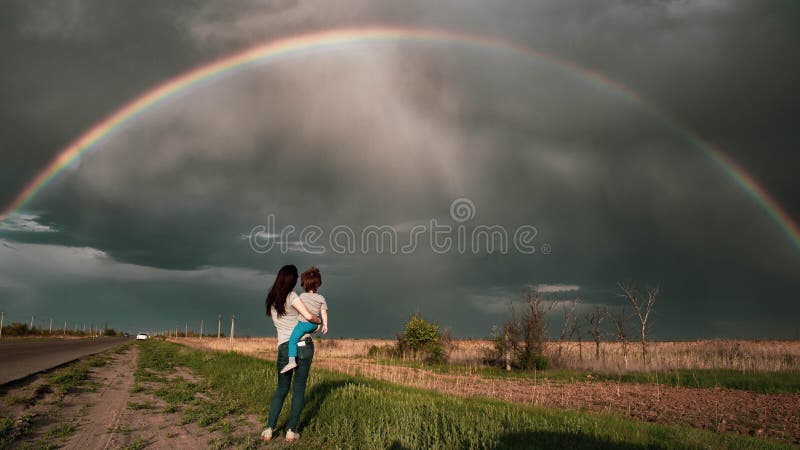 Rainbow Over Field with People. Mom and Son Look at the Rainbow Stock ...