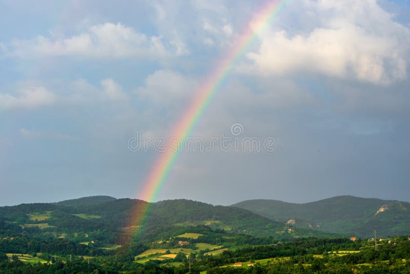 Rainbow over a field stock photo. Image of color, outdoor - 189585970