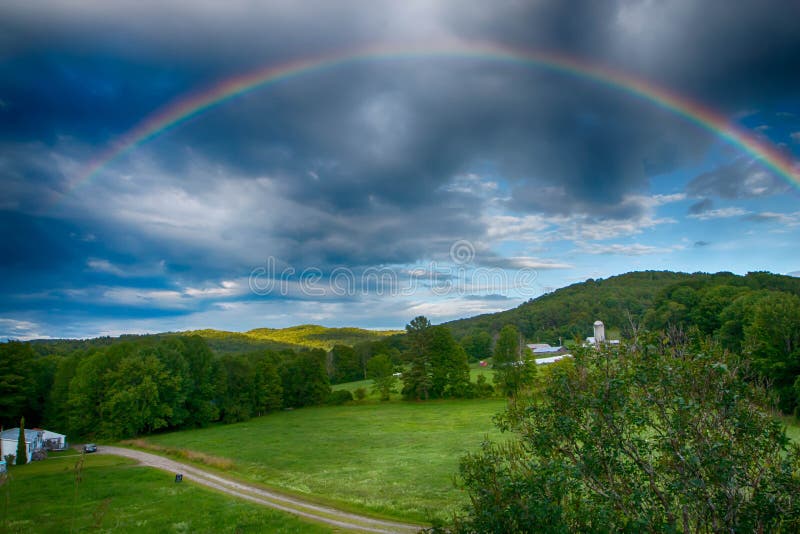 Rainbow over the hillside stock image. Image of blue - 121949677