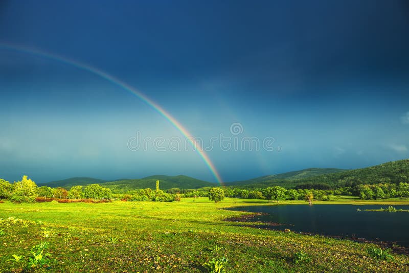 Rainbow over a lake stock image. Image of grass, scenery - 71603283