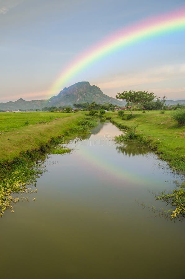Rainbow and Reflection on the River. Mountain in the Distance Stock ...