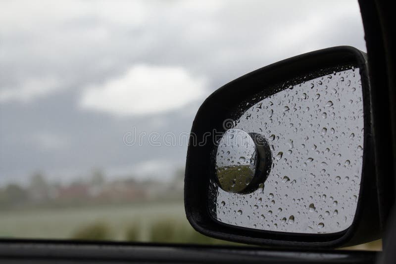 Raindrops on a Car Mirror Against the Background of Rain Clouds Stock ...