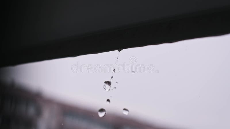 Raindrops Falling on a Window with a Blurred View of Trees and ...