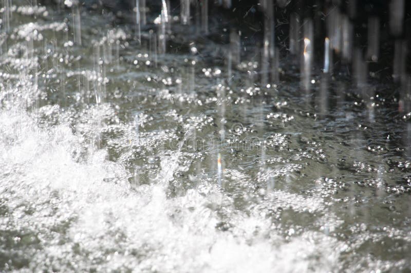 Raindrops Hitting Water Surface with Splashes and Ripples - Close Up in ...