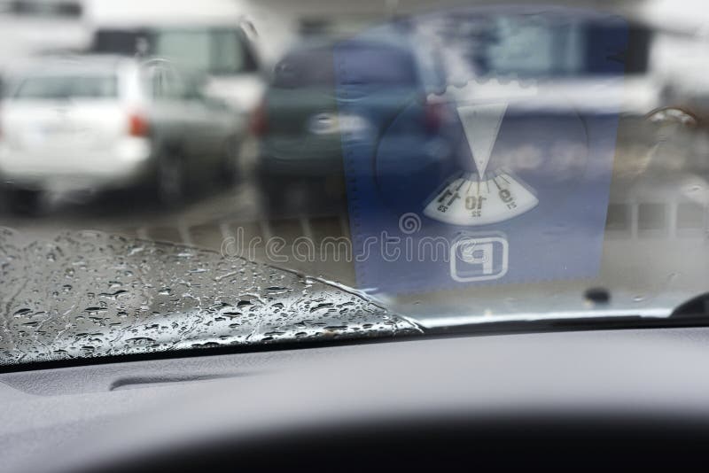 Raindrops and Reflection of Parking Disk on a Car Windshield Stock ...