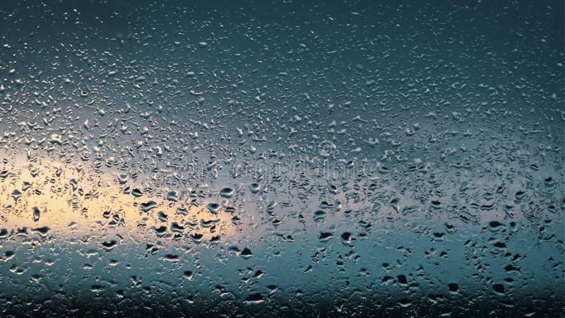 Raindrops Slowly Flow Down the Glass of the Window Against the Sunset ...