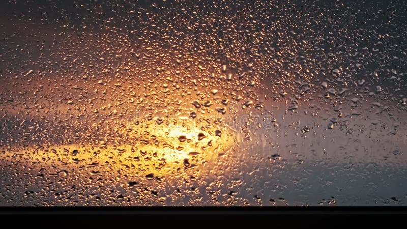 Raindrops Slowly Flow Down the Glass of the Window Against the Sunset ...