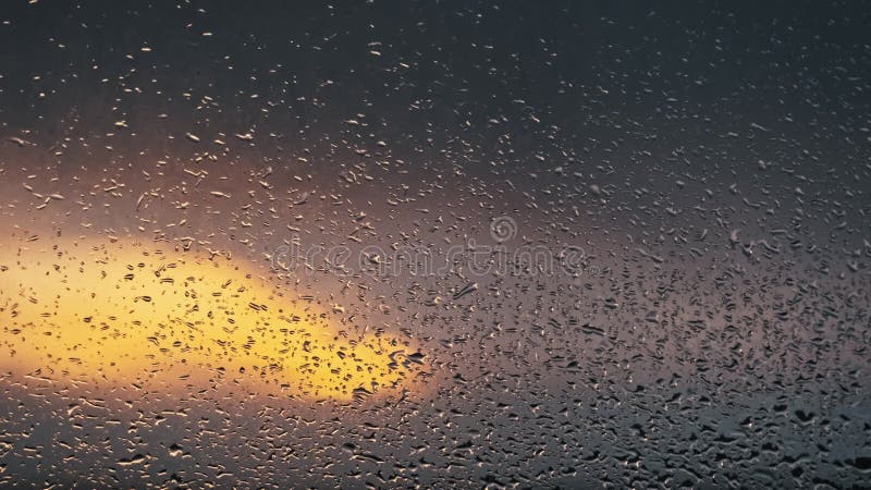 Raindrops Slowly Flow Down the Glass of the Window Against the Sunset ...