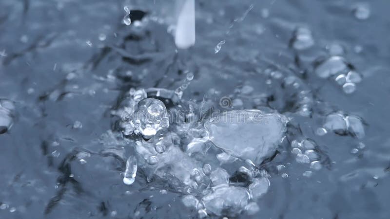Rainwater Drops Drip into a Puddle. a Close-up of the Drain. Raindrops ...