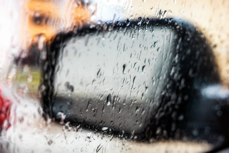 Rainy Weather and Rain Drops on Glass of Car. View on Rearview Mirror ...