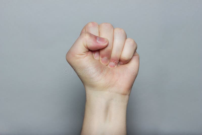 Raising Up Left Fist in Front of Grey Background Stock Image - Image of ...