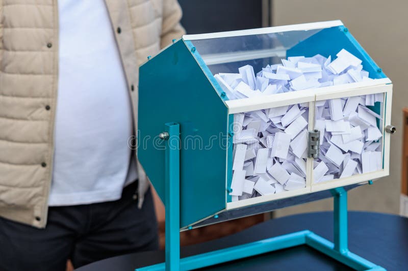 Random Drawing Lottery Drum with White Paper Slips in a Blue Box Stock ...