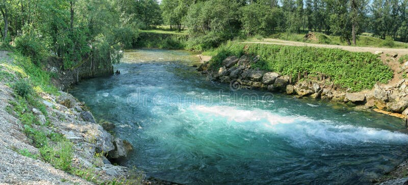 A Shallow River With Clear Water And A With Stones Flowing Among Stock ...