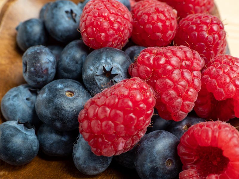Raspberries and Blueberries on a Wooden Background. Stock Photo - Image ...