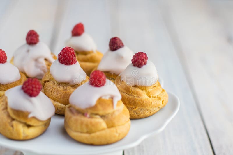 Raspberries Profiteroles with White Chocolate on White Plate Stock ...