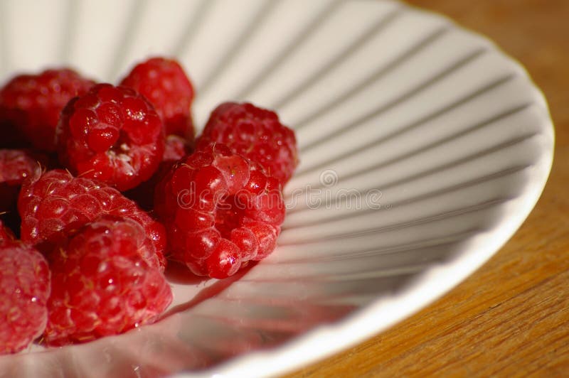 Raspberries on white plate stock photo. Image of fresh - 1676476