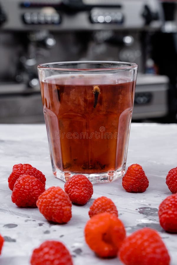 Raspberry Tea on White Steel, Against the Background of a Blurry Bar ...