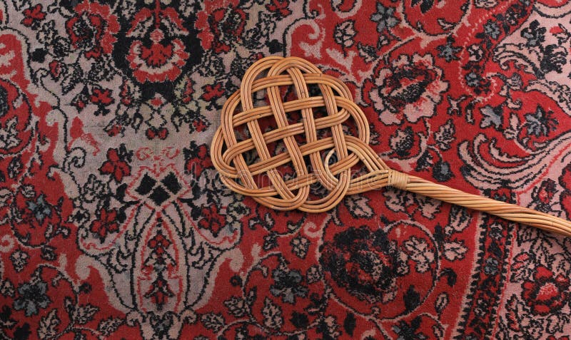 Rattan beater on carpet stock photo. Image of cleaning - 335267256