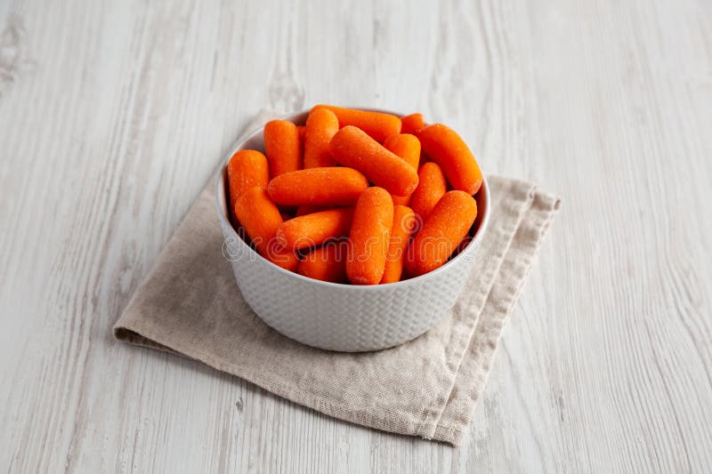 Raw Baby Carrots in a Bowl on a White Background, Side View Stock Photo ...