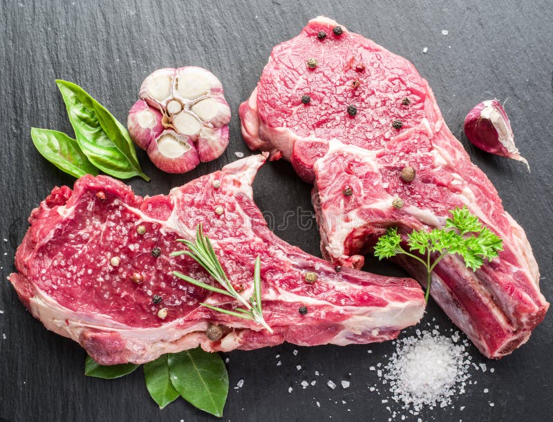 Raw Beaf Steaks with Spices on the Cutting Board. Stock Photo - Image ...