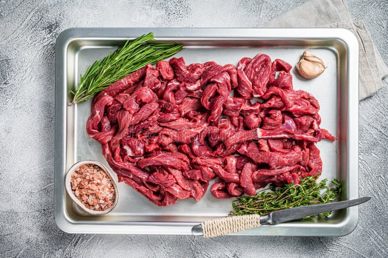 Raw Beef Strips Slices in a Kitchen Tray with Rosemary and Thyme. White ...