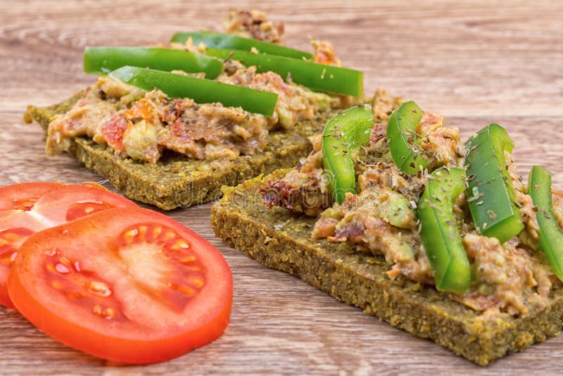 Raw Bread with a Spread Decorated with Pepper and Tomatoes Stock Photo ...