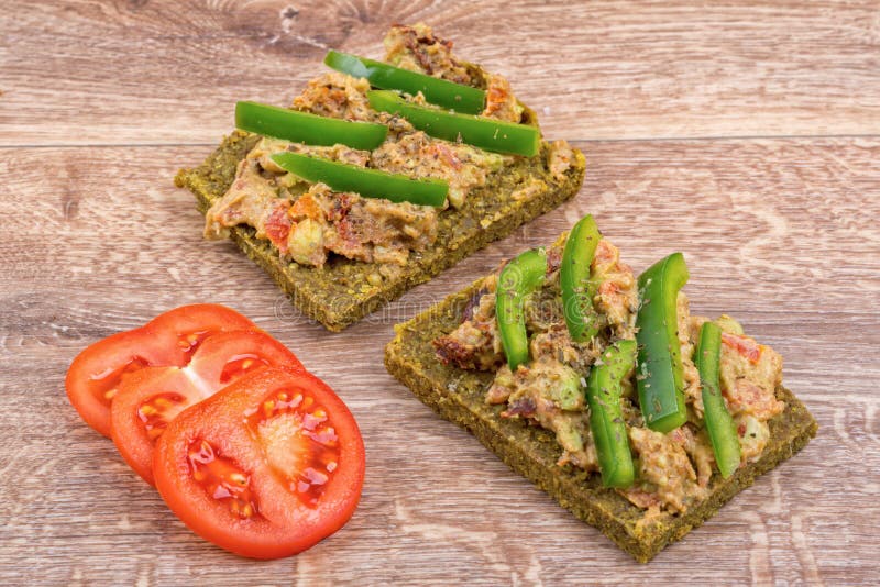 Raw Bread with a Spread Decorated with Pepper and Tomatoes Stock Photo ...
