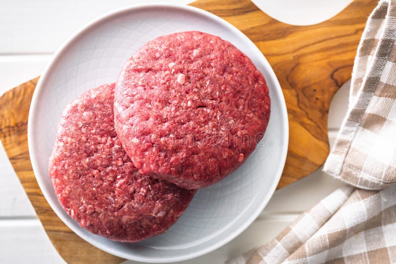 Raw Burger Beef Patties on Plate on White Table. Top View Stock Photo ...