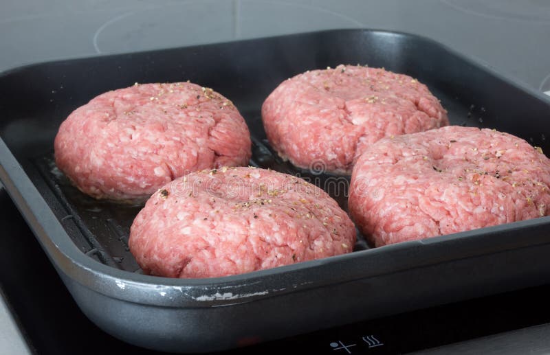 Raw Burgers, Beef in a Frying Pan on Cooking Surface in Kitchen Stock ...