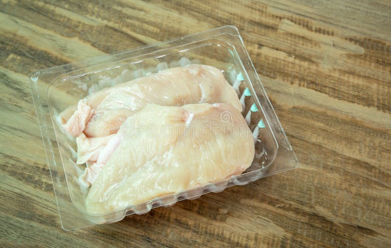 Raw Chicken Breast in Plastic Pack on Wooden Background Stock Photo ...