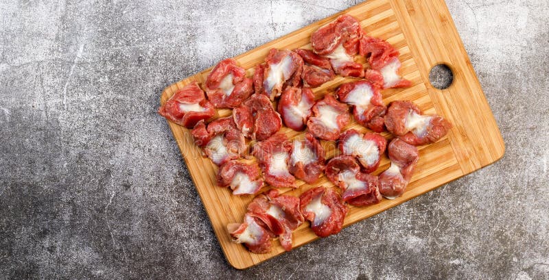 Raw Chicken Gizzards on a Rectangular Cutting Wooden Board on a Dark ...